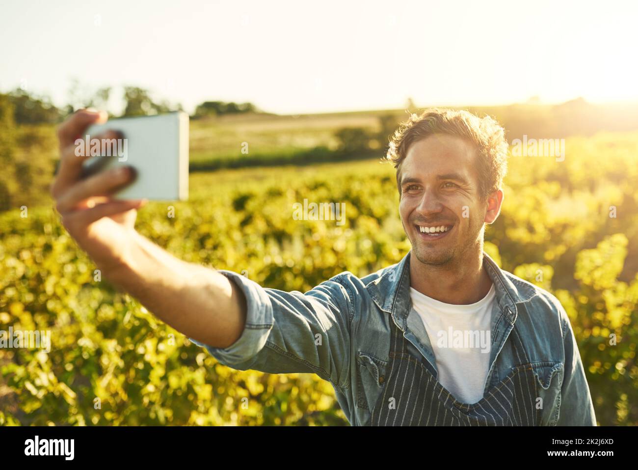 All about that farm life. Shot of a young man taking a selfie with his ...