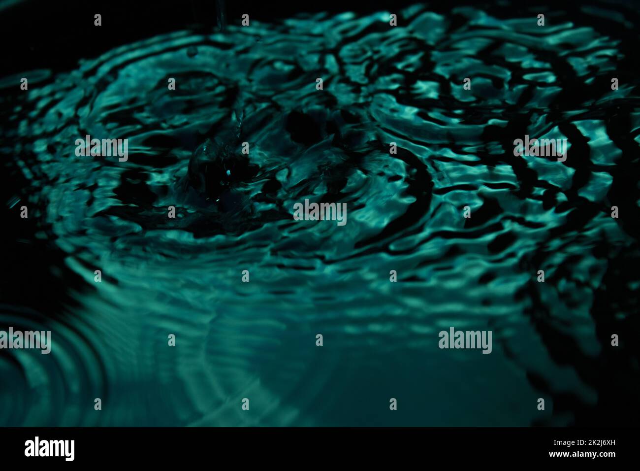 Drop of water jumping over the surface Stock Photo - Alamy