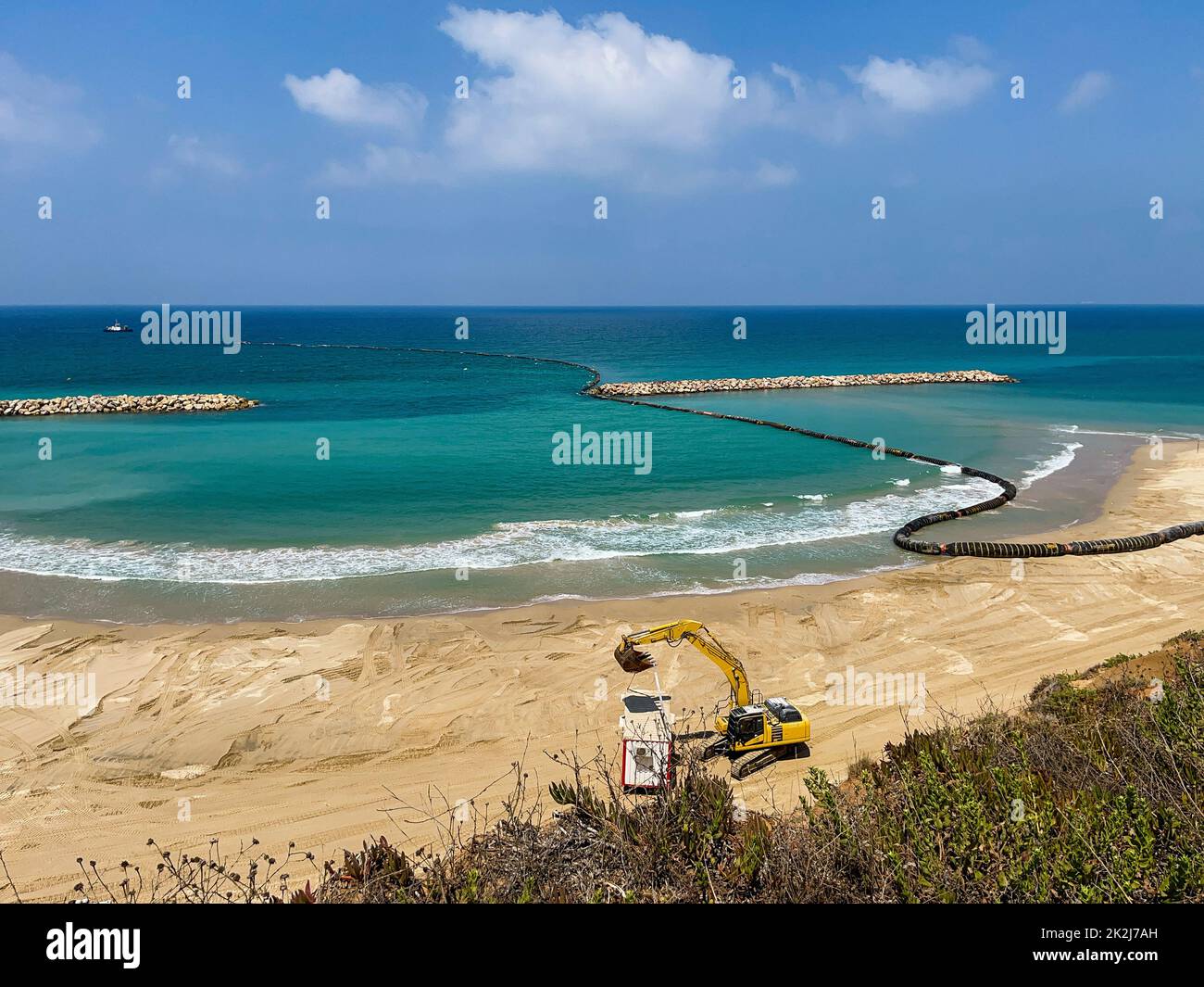 The excavator transports a change house for workers. Building a beach ...