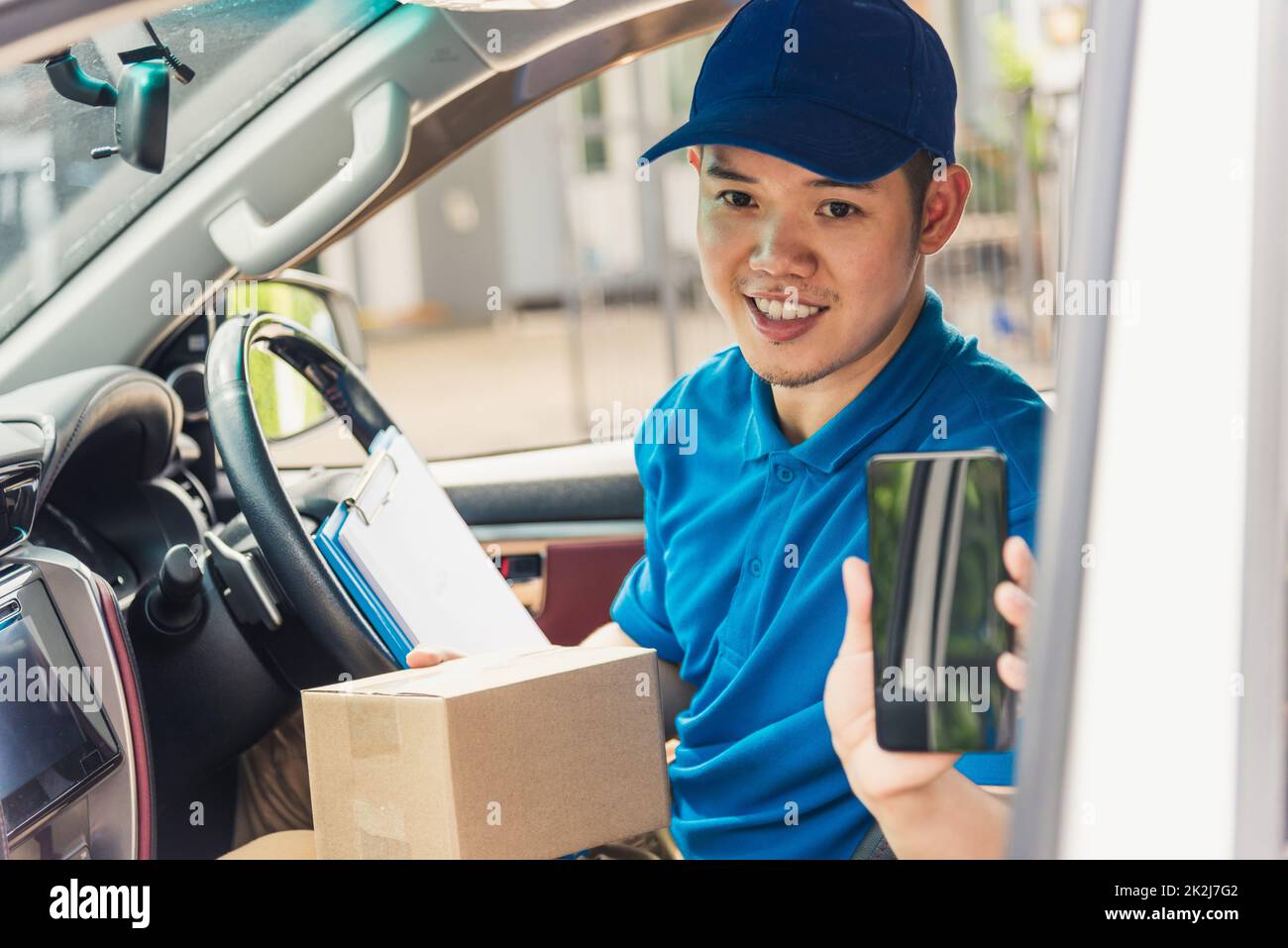 delivery man courier online holding deliveries out boxes inside the car ...