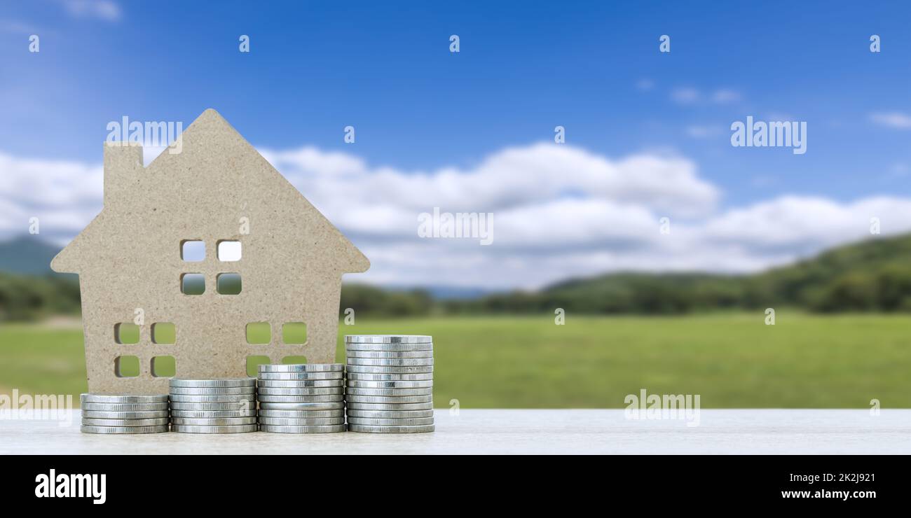 House model and stack of coins with landscape background Stock Photo ...