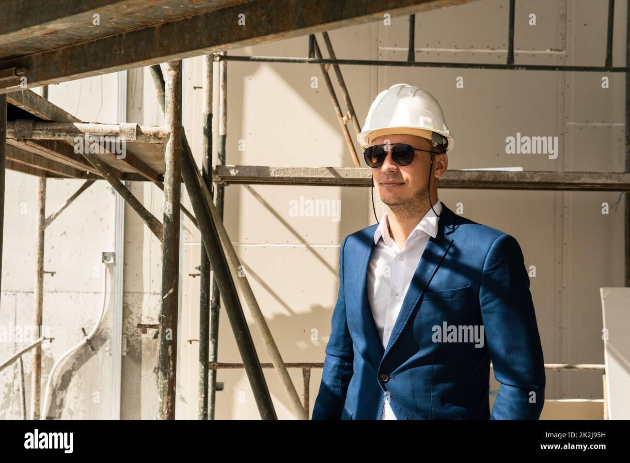 Architect or businessman wearing formal suit and hard hat on a ...