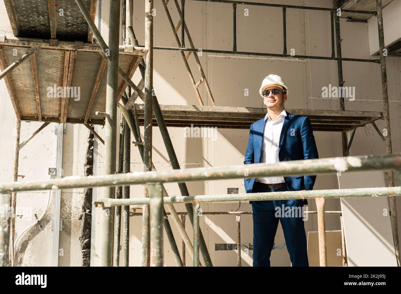 Architect or businessman wearing formal suit and hard hat on a ...