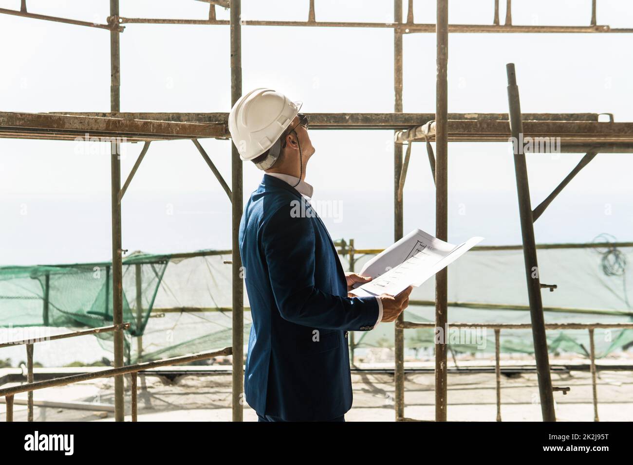 Man architect wearing formal suit and hard hat during building ...