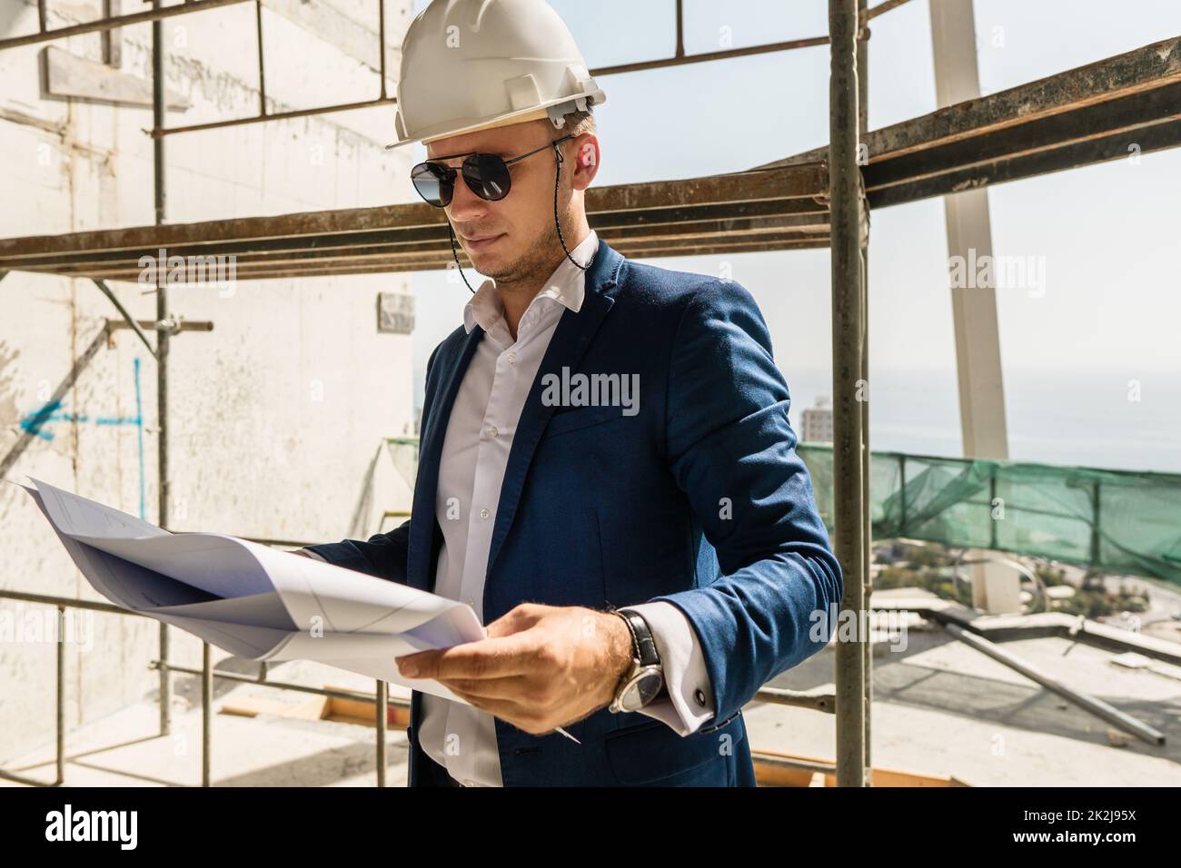 Man architect wearing formal suit and hard hat during building ...