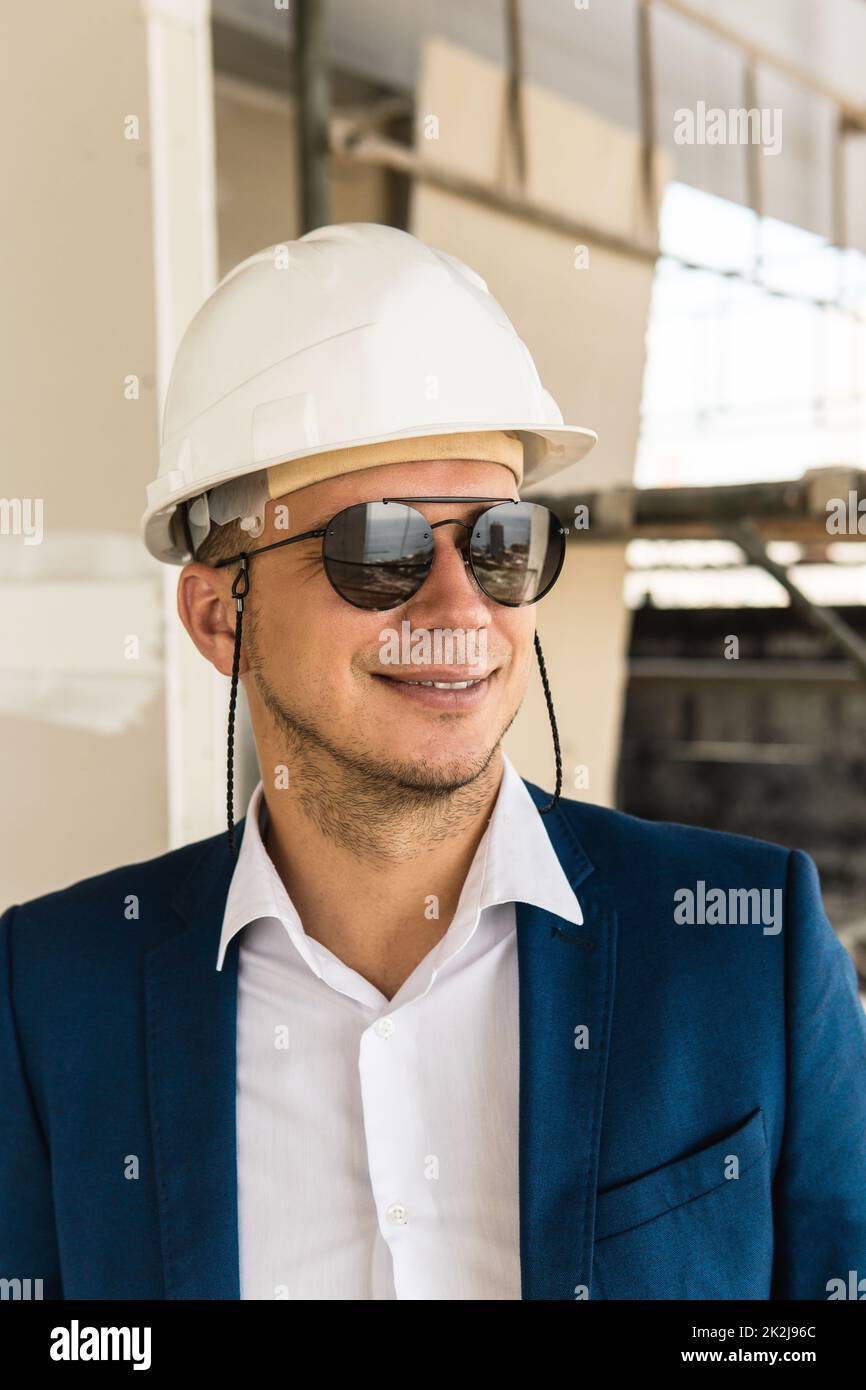 Architect or businessman wearing formal suit and hard hat on a ...