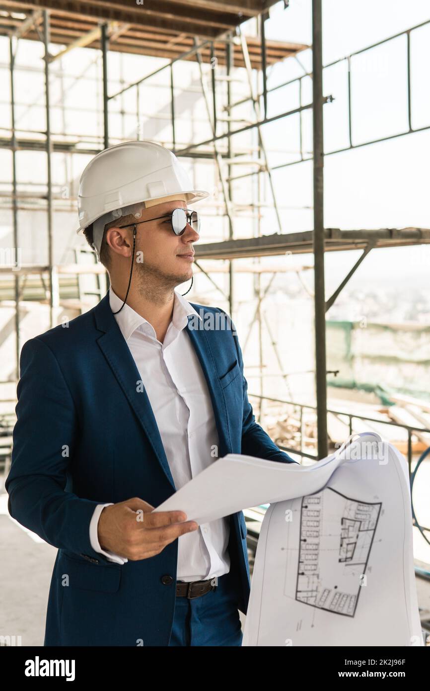Man architect wearing formal suit and hard hat during building ...