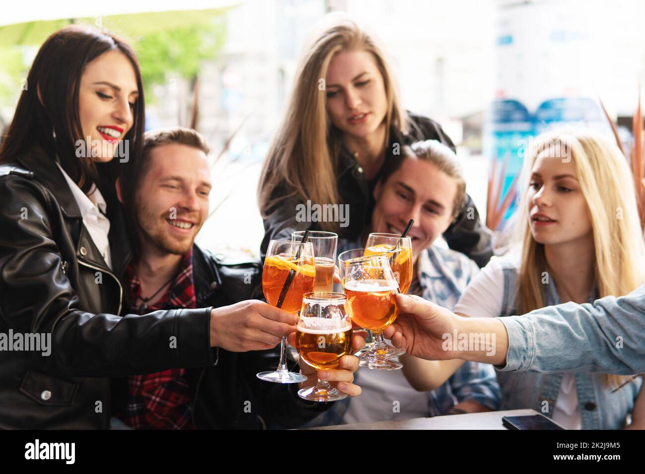 Friends celebrating and holding glasses with different alcohol drinks ...