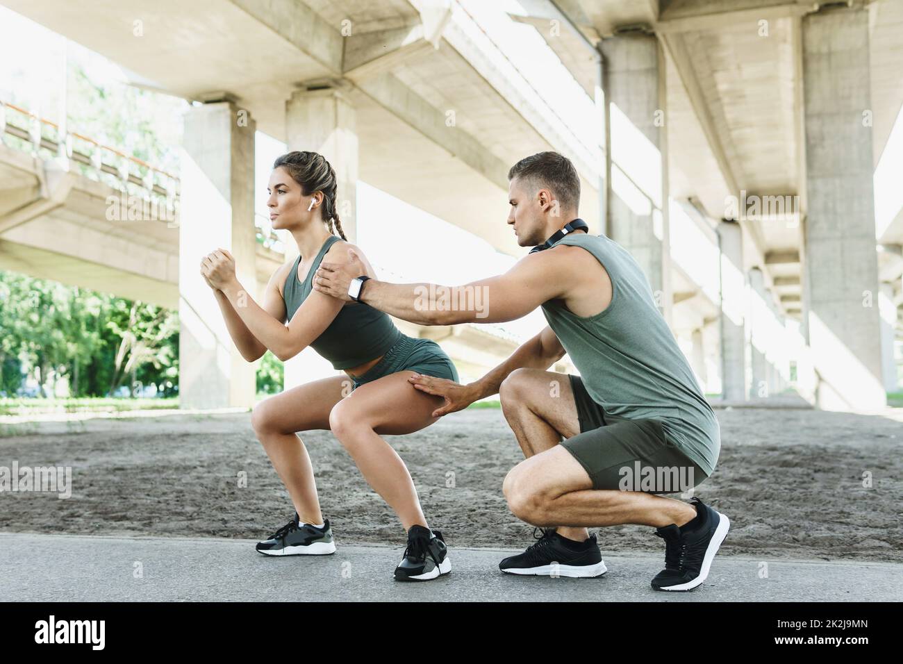 Athletic couple doing squats during street workout Stock Photo - Alamy