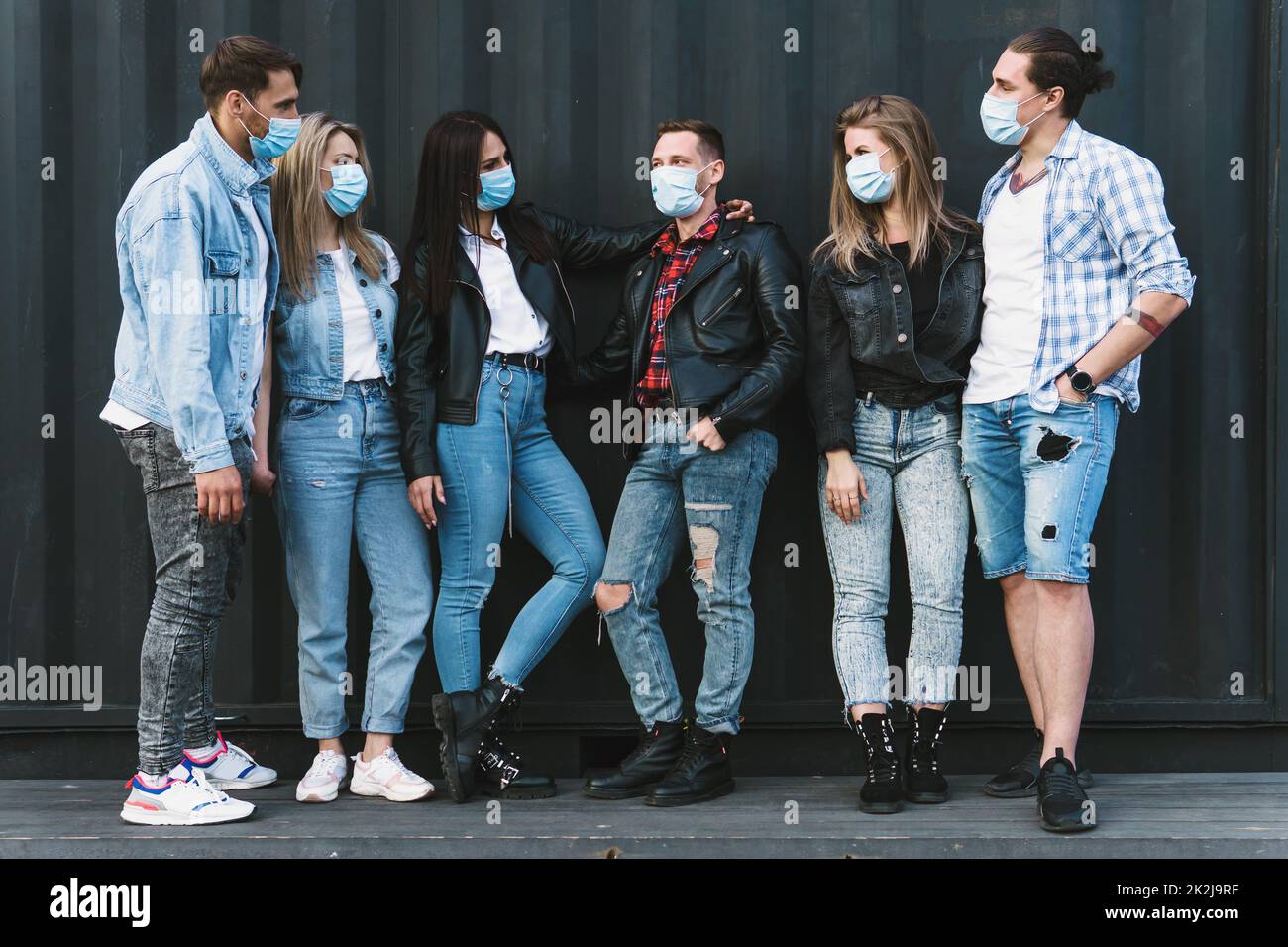 Group of friends wearing prevention masks during their meeting outdoors ...