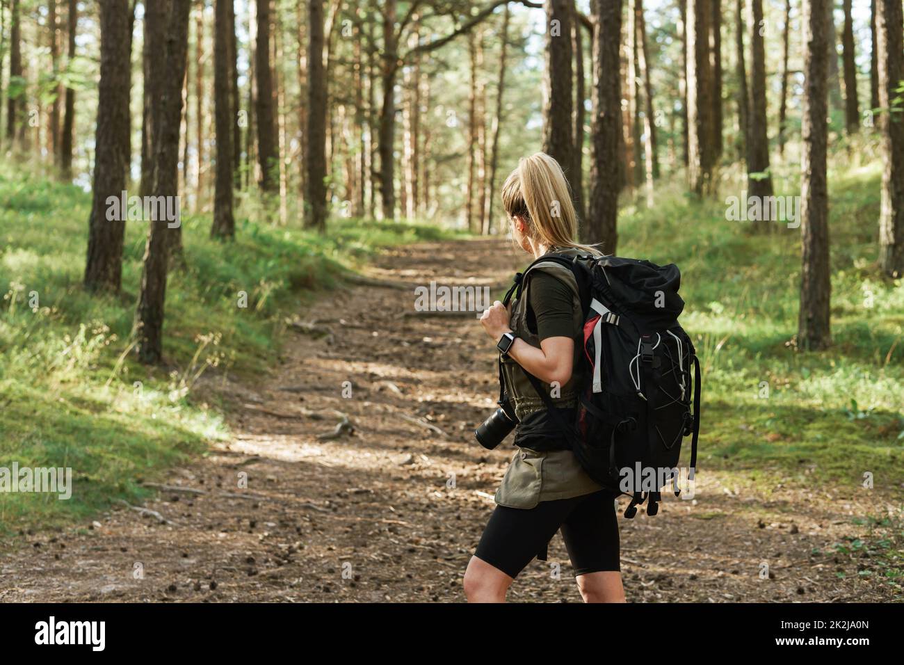 Female hiker with big backpack in green forest Stock Photo - Alamy
