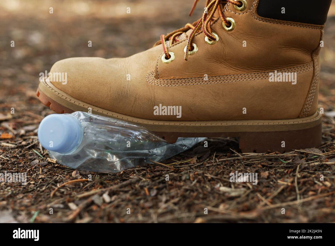 Yellow boots and plastic bottle in a forest Stock Photo - Alamy