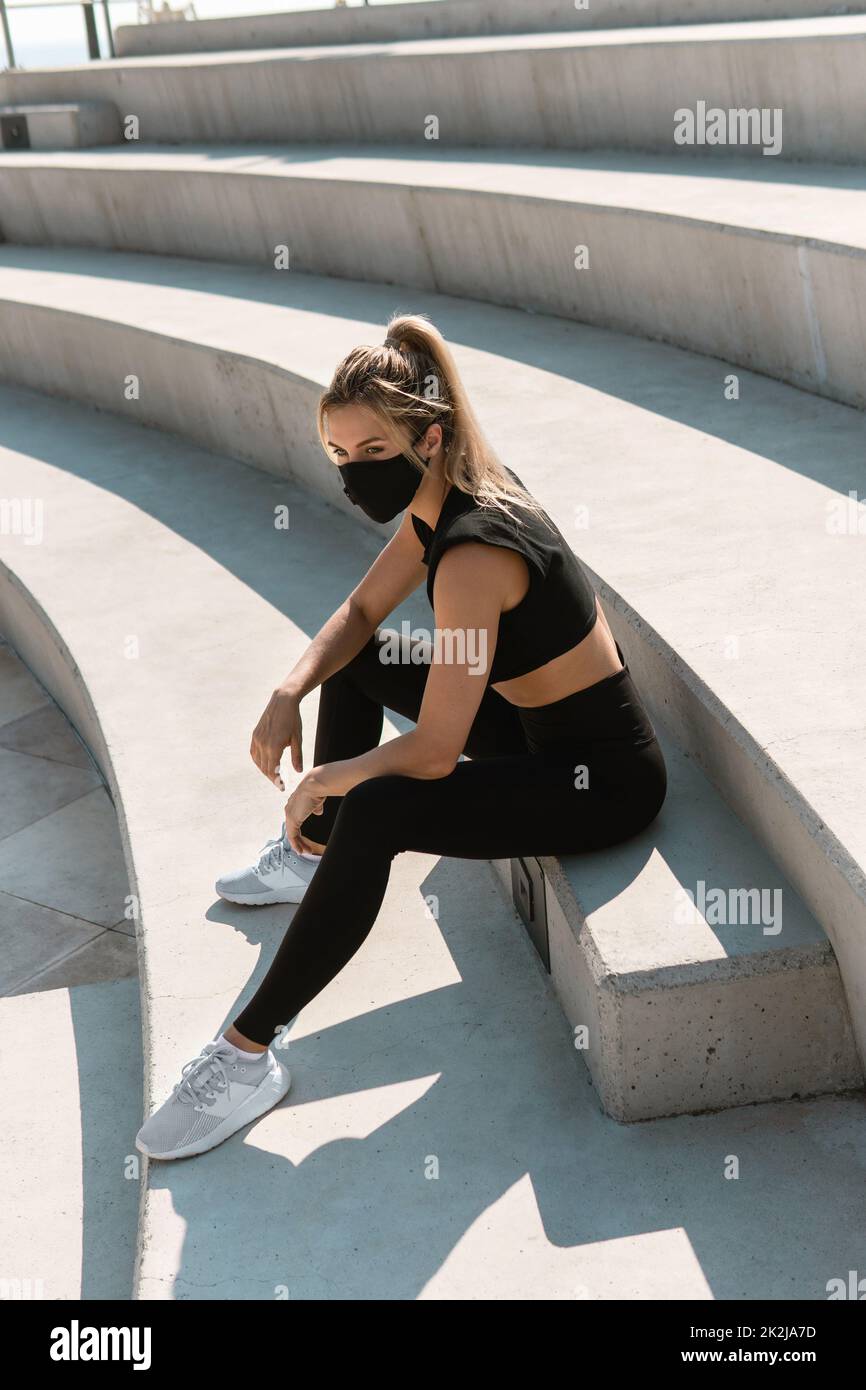 Athletic woman wearing face mask during summer street workout Stock ...