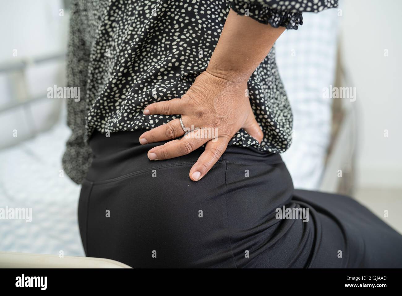 Asian lady patient wearing back pain support belt for orthopedic lumbar ...