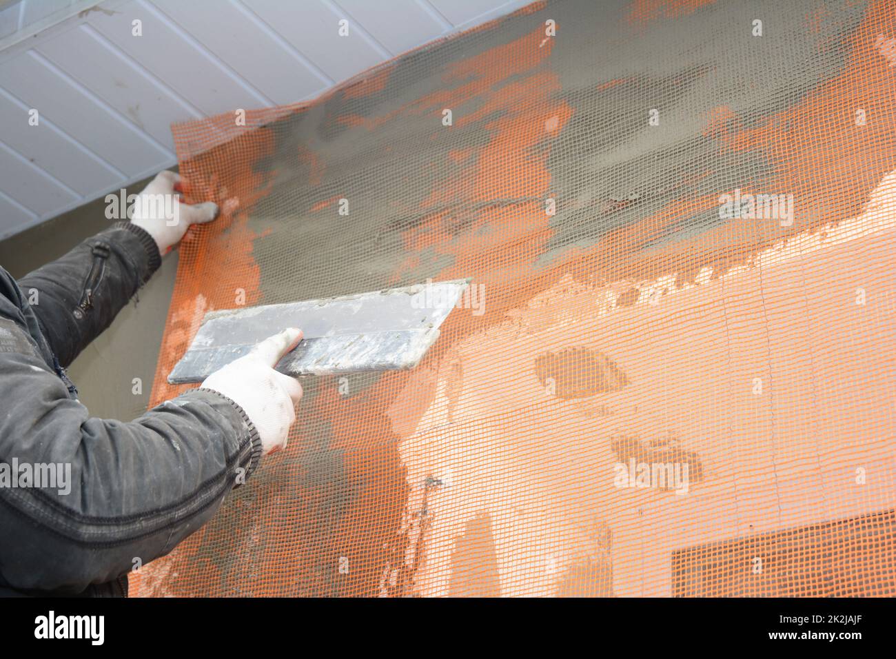 Builder contractor plastering wall with spatula, fiberglass mesh ...