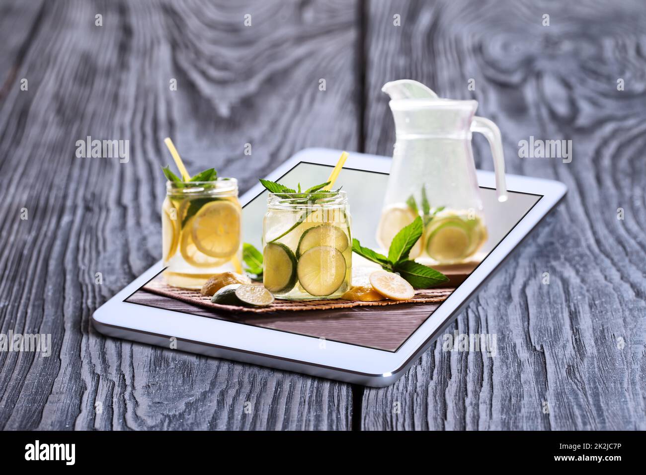 Jug and cans of lemonade on the screen of tablet computer Stock Photo ...