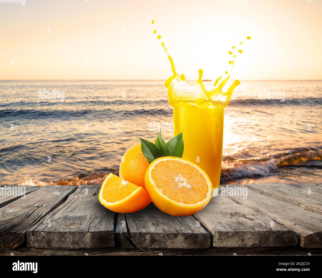 Splash of orange juice in glass on background of sea landscape Stock ...