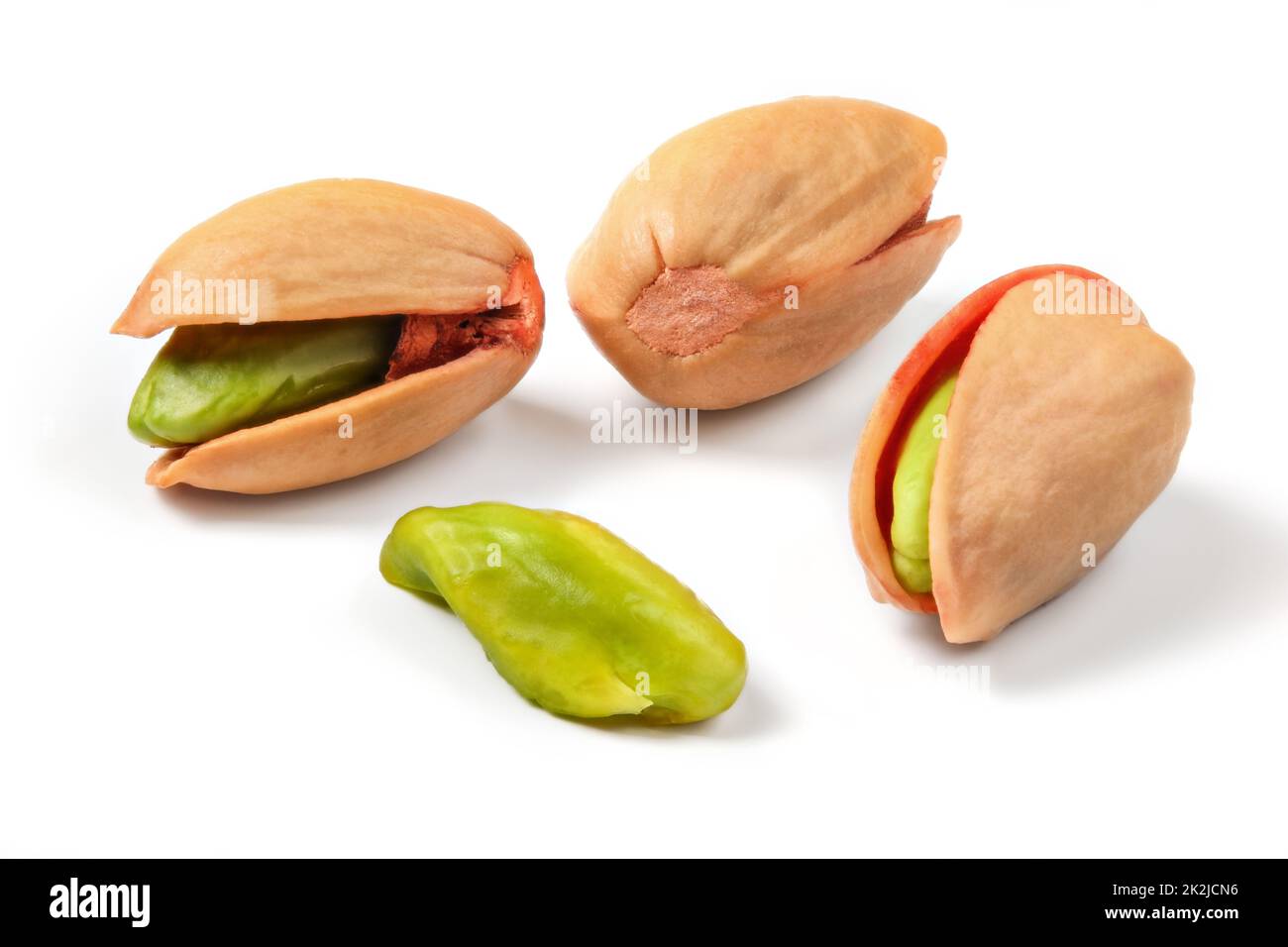 Turkish red roasted pistachios in shell, some of green nuts visible, isolated on white ...