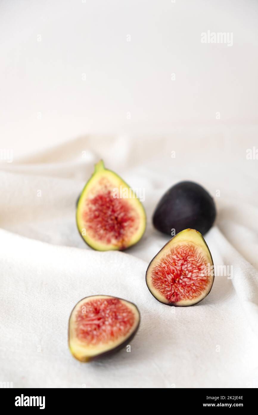 Fresh ripe and sweet figs cut and whole on beige color table cloth ...