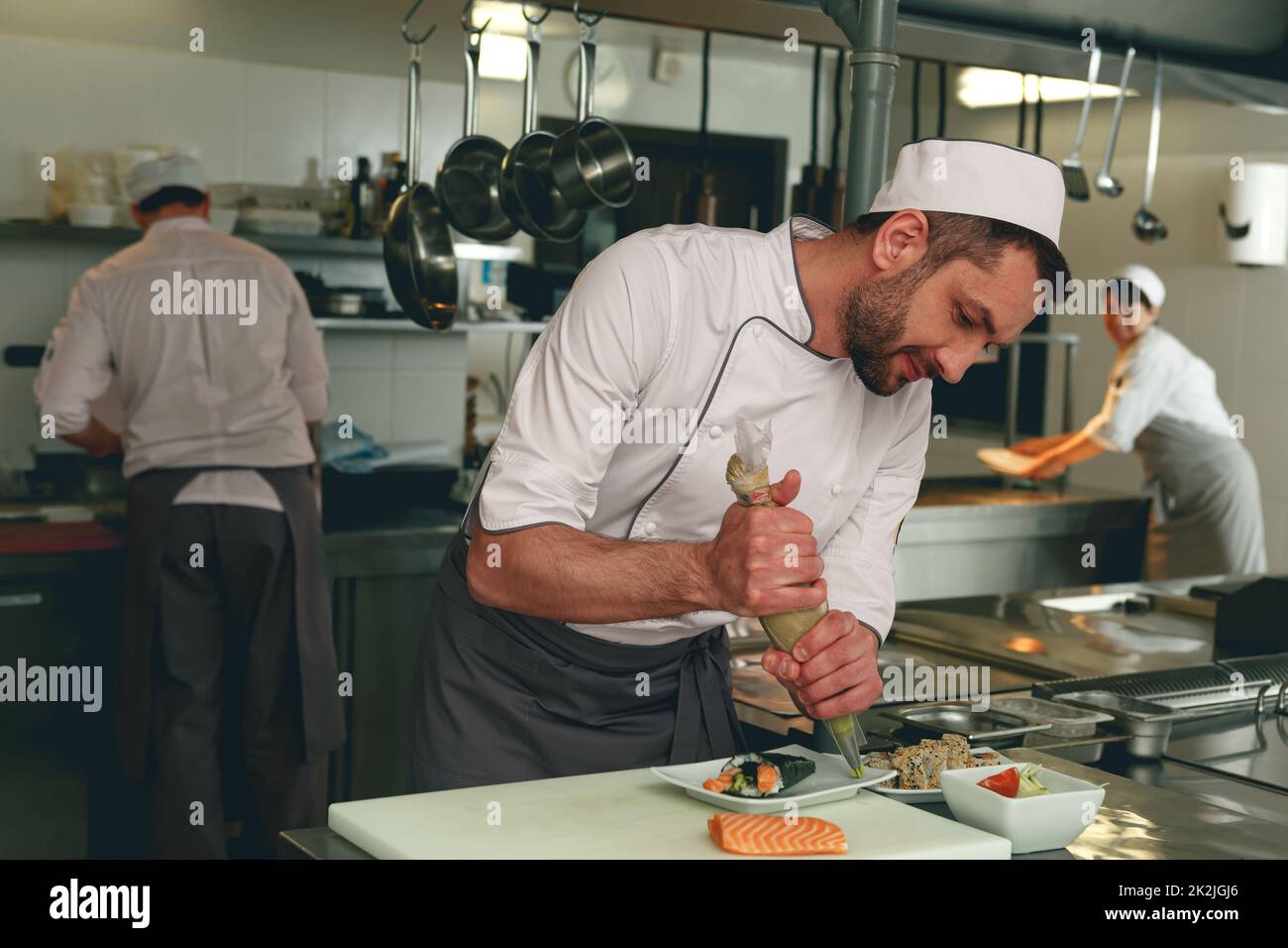 Professional Male Chef in uniforms preparing sushi in a kitchen of ...