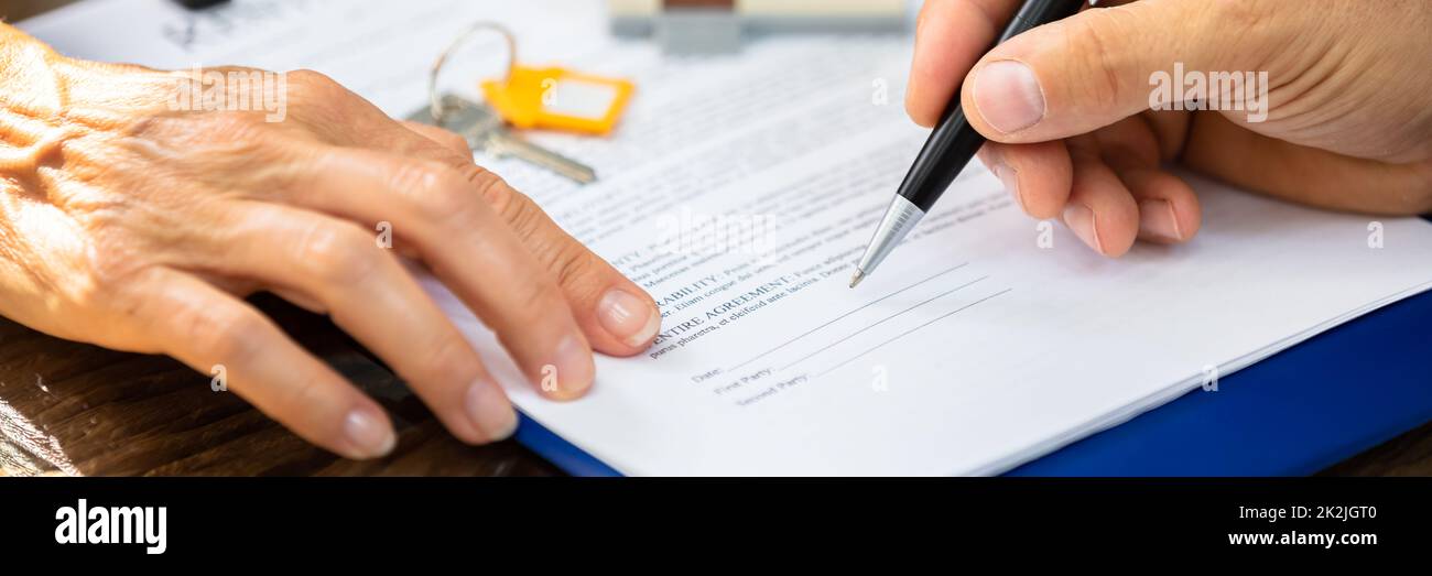 Real Estate Agent Helping Client In Filling Contract Form Stock Photo ...