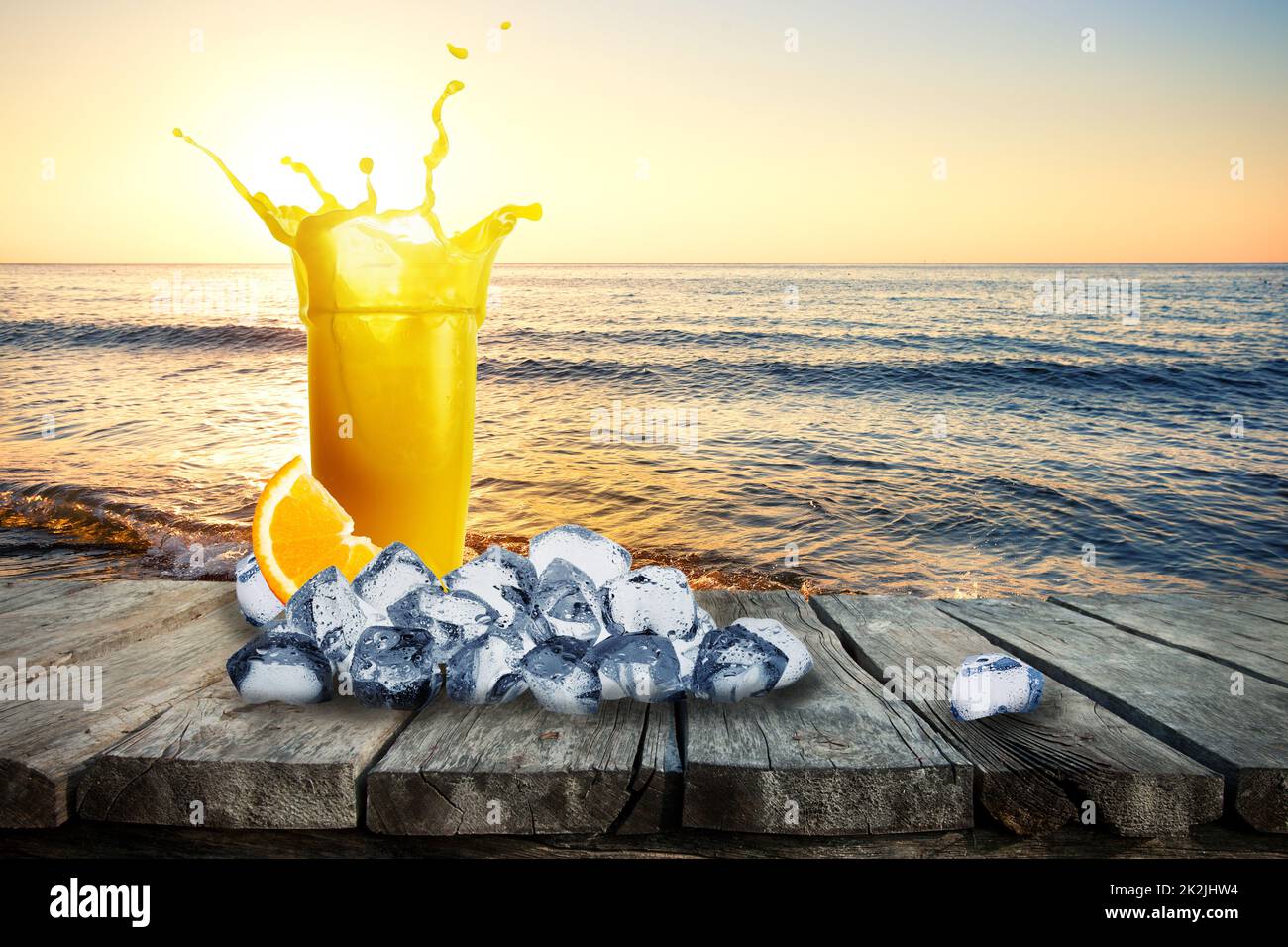 Glass of orange juice with splash and ice on wooden table on bac Stock ...