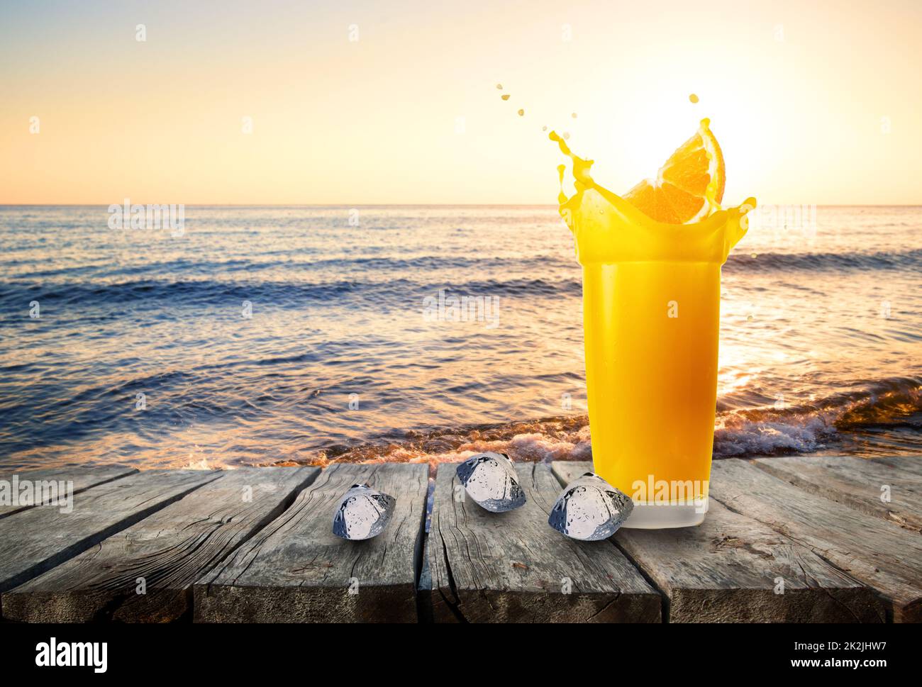 Glass of orange juice with splash from orange slice and ice Stock Photo ...