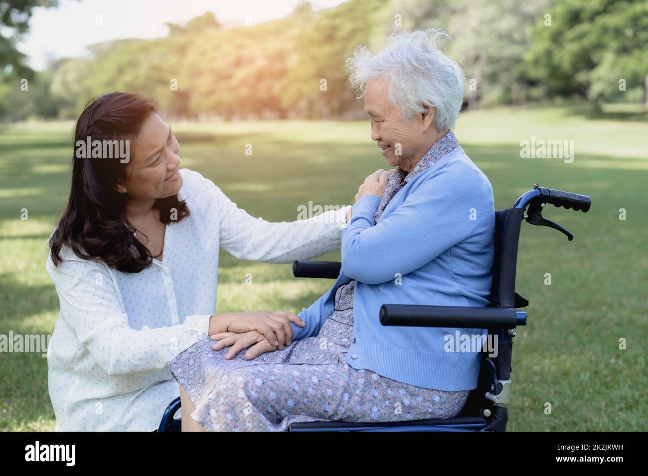 Caregiver help and care Asian senior or elderly old lady woman patient sitting on wheelchair in ...