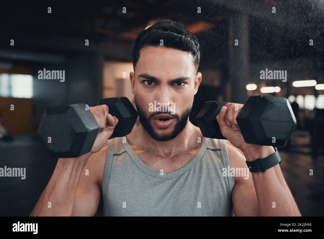 Theres no stopping this train. Shot of a young man using weights in the ...