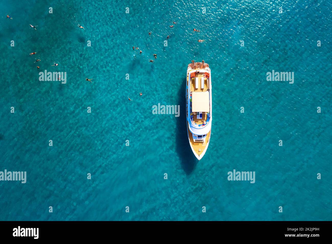Seashore cruise boat with tourists swimming next to it Stock Photo - Alamy