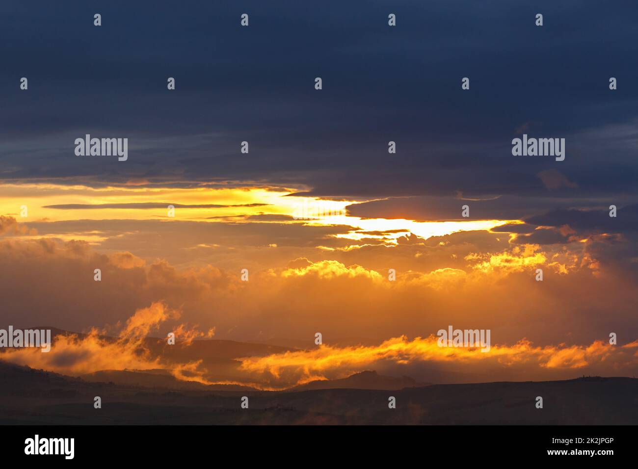 Low clouds in backlight over a landscape at sunset Stock Photo - Alamy