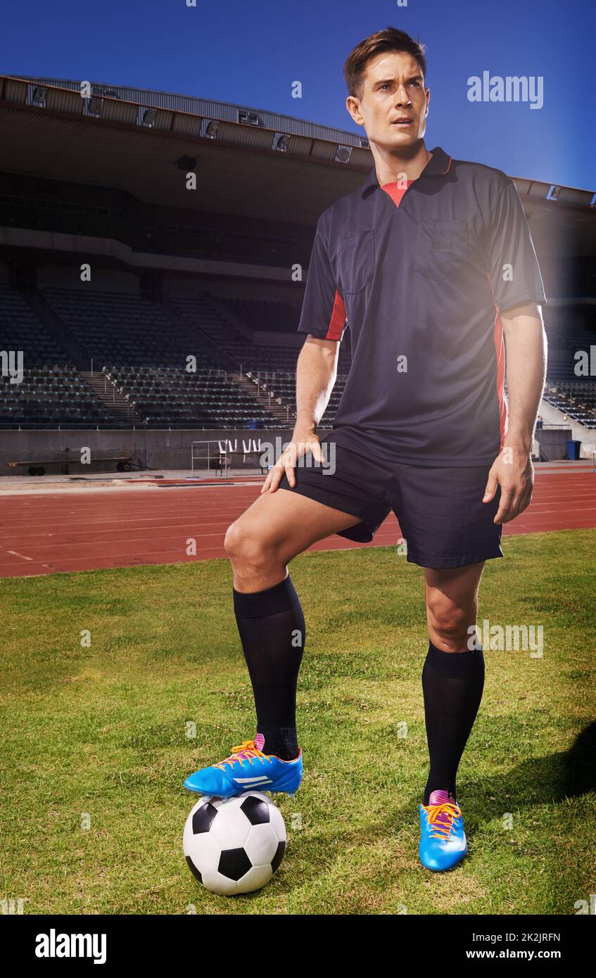 Ready for the next game. a young footballer standing on a field with a ...