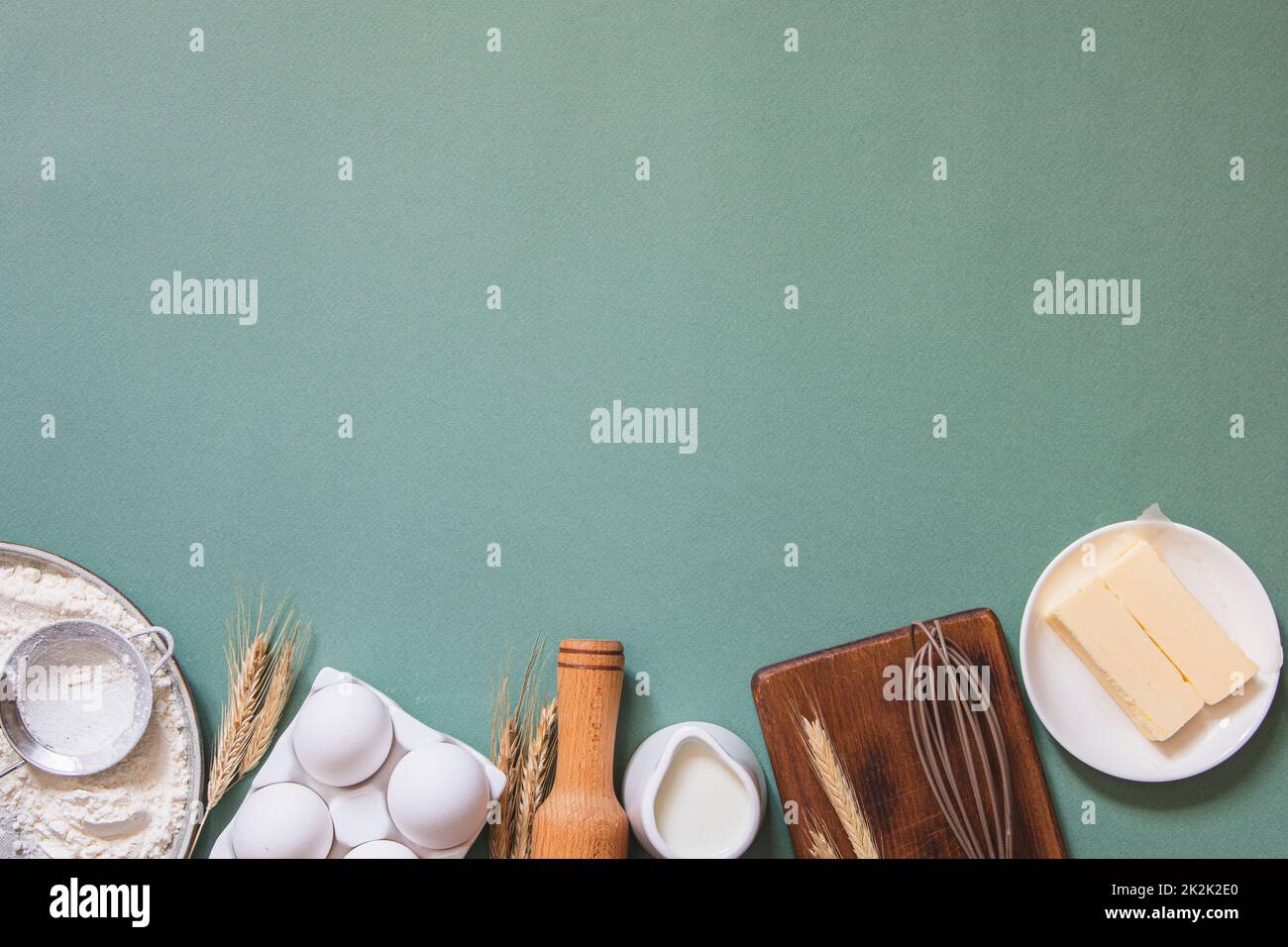 Frame of food ingredients for baking on a green pastel background ...