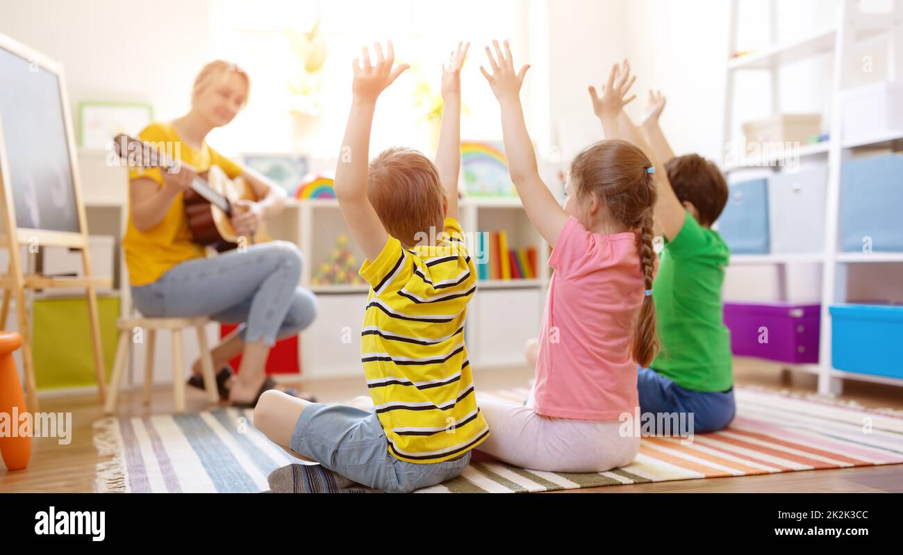 Group of children and teacher in the music class. Children sitting on ...
