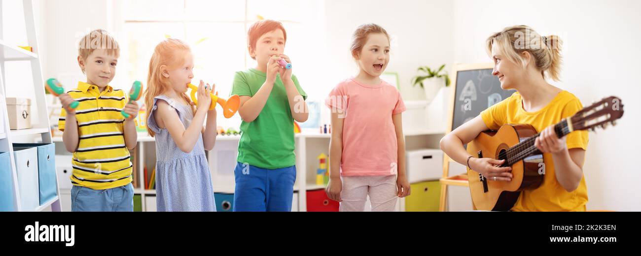Group of children and teacher in the music class. Kids playing on the ...