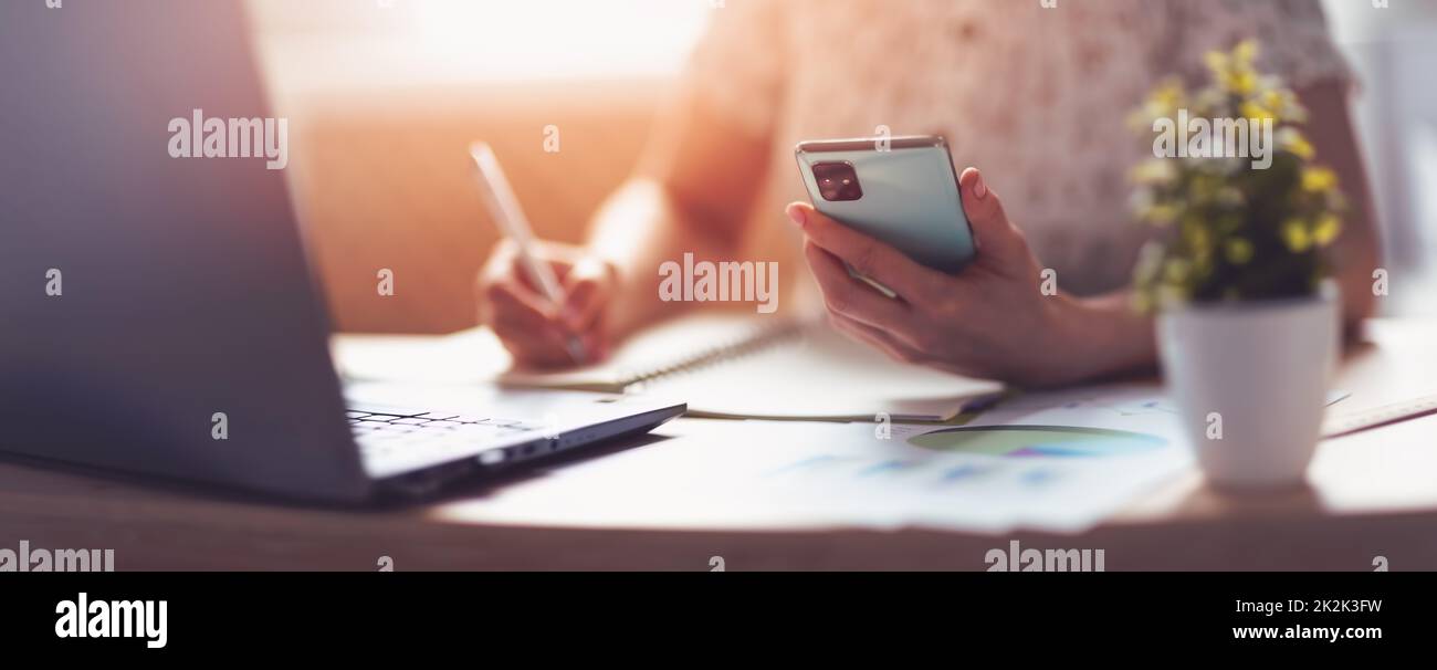 Woman writing in notebook and reading messages Stock Photo - Alamy