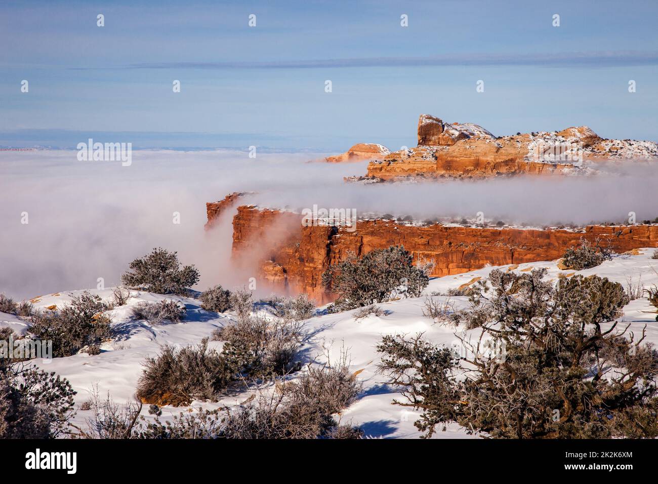 Low clouds flow off the mesa at the Green River Overlook during a ...