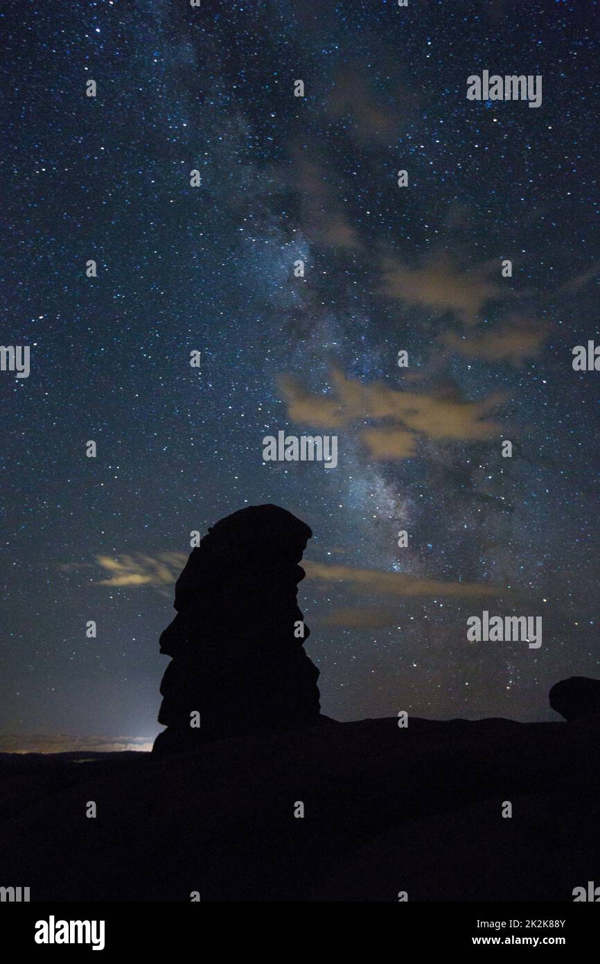 Stars and clouds over an Entrada sandstone rock spire at night in ...