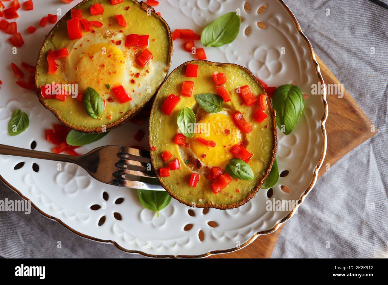 Keto diet. Healthy breakfast of baked avocado and eggs boats with herbs ...