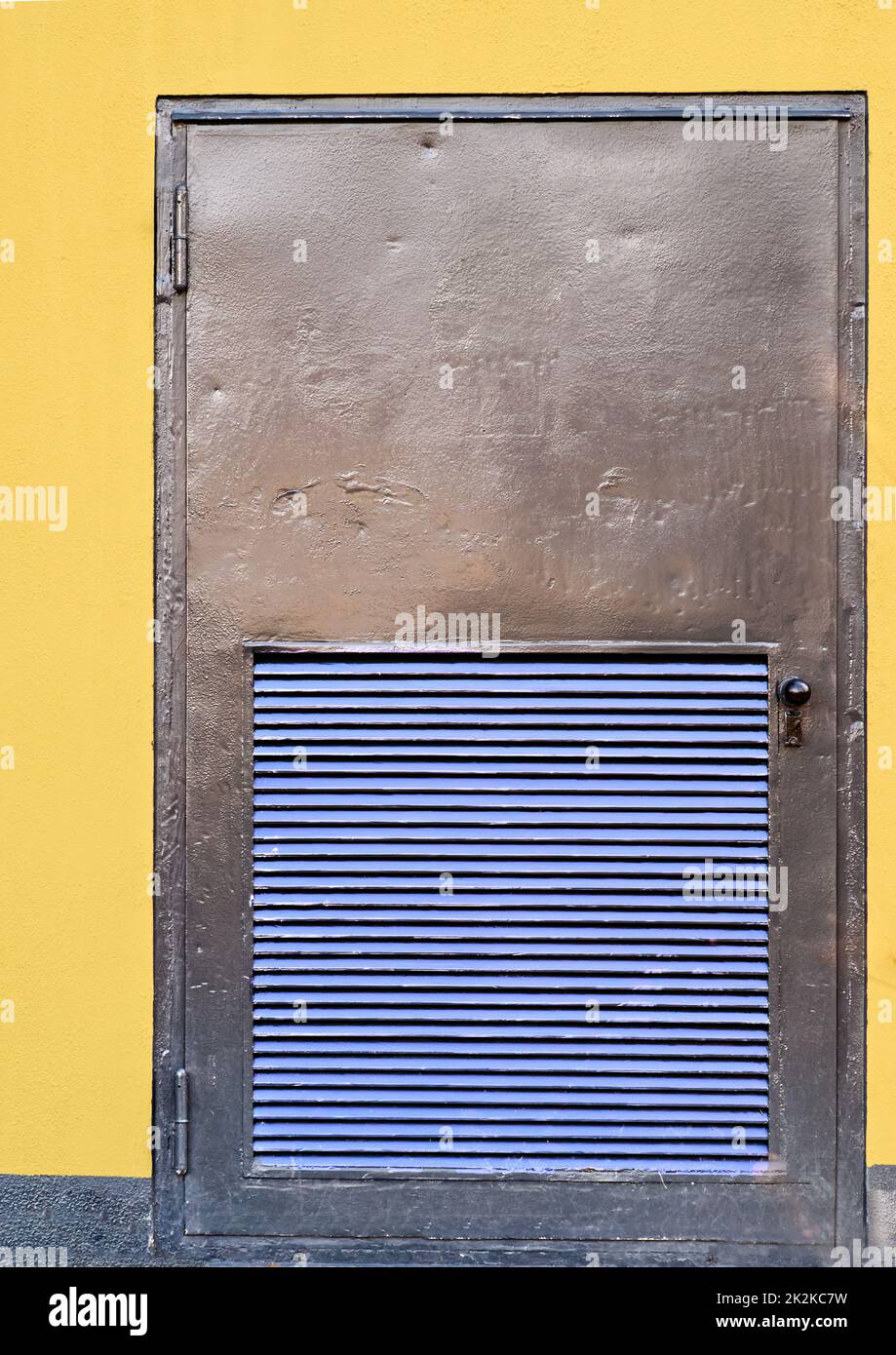 close up of a metal door of a transformer building, yellow painted ...