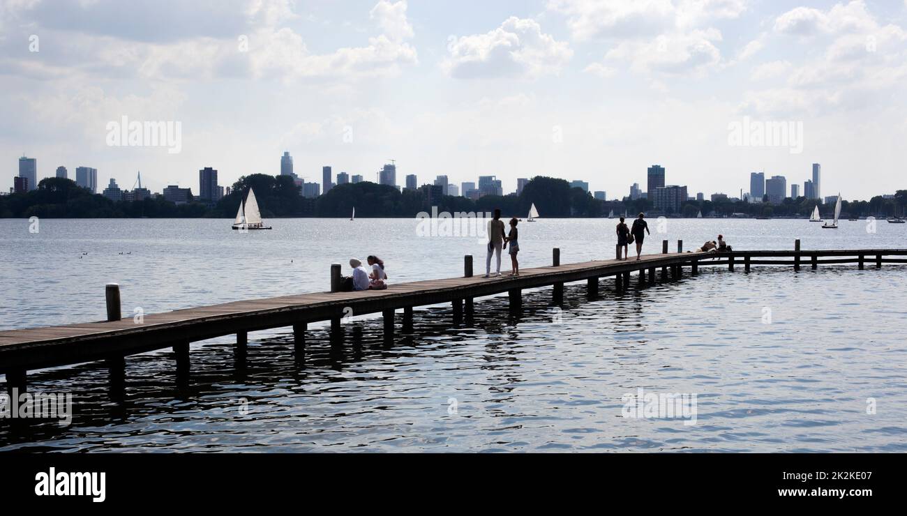 People chilling on a Jetty in the Kralingse Plas with the skyline of ...