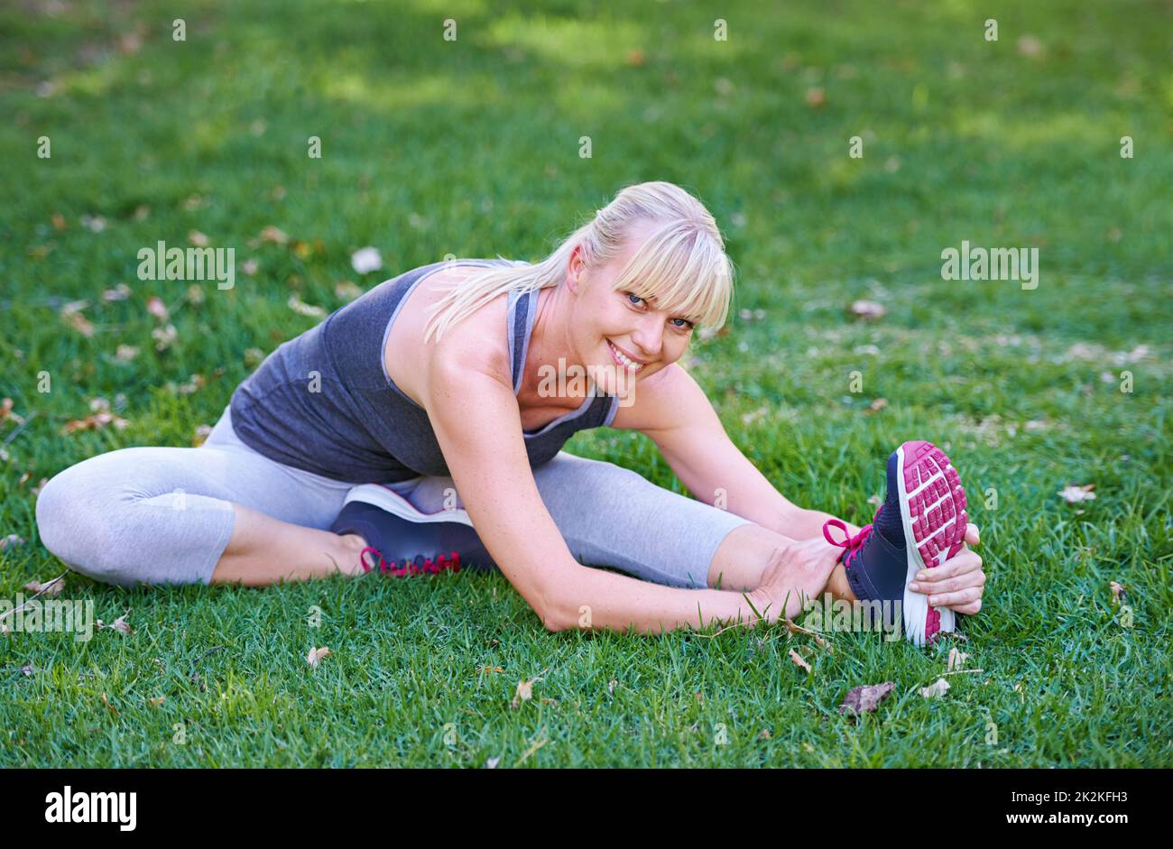 The world is beautiful from this angle. a young woman stretching on a ...