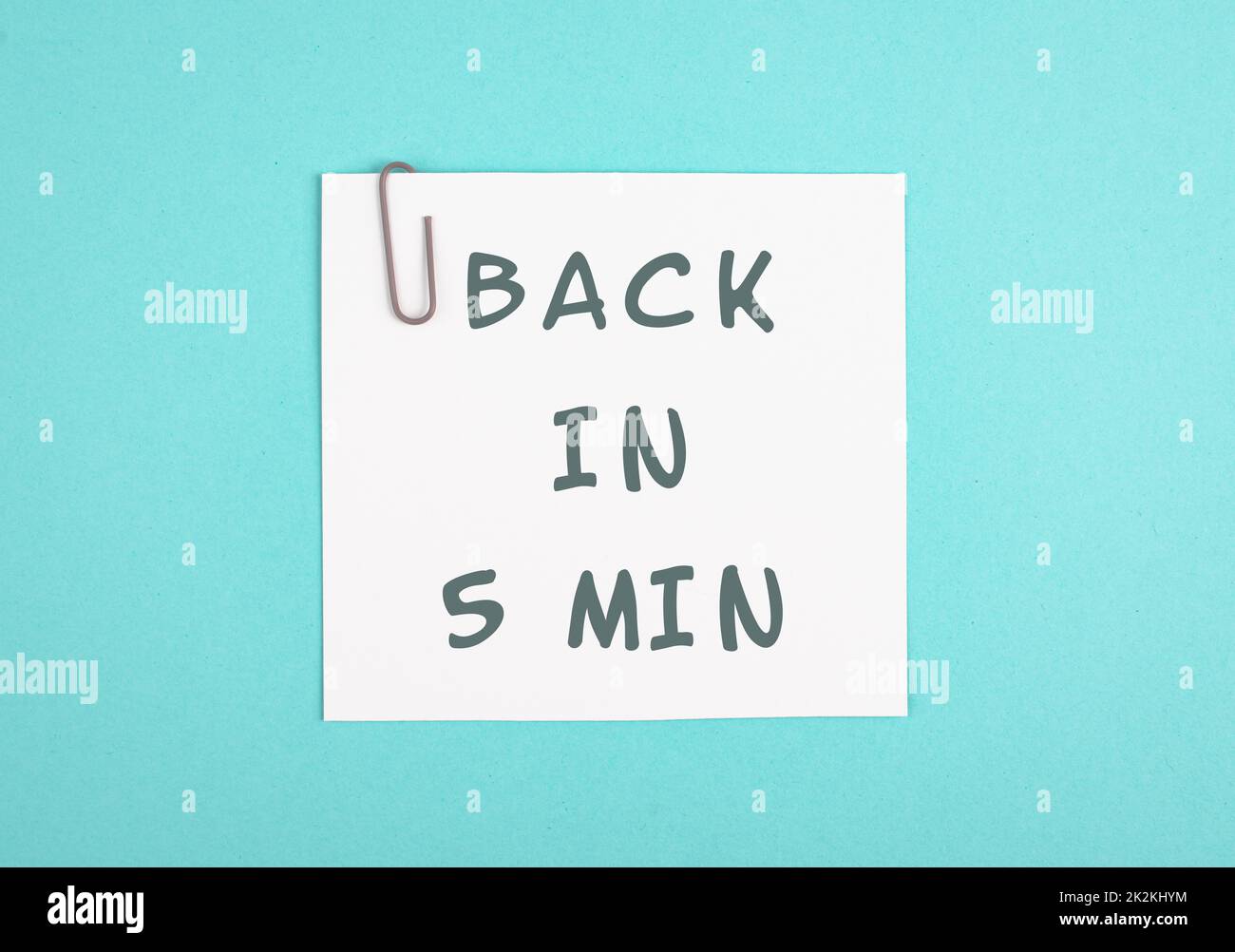 Back in 5 min ist standing on a paper, hands hold message, working ...