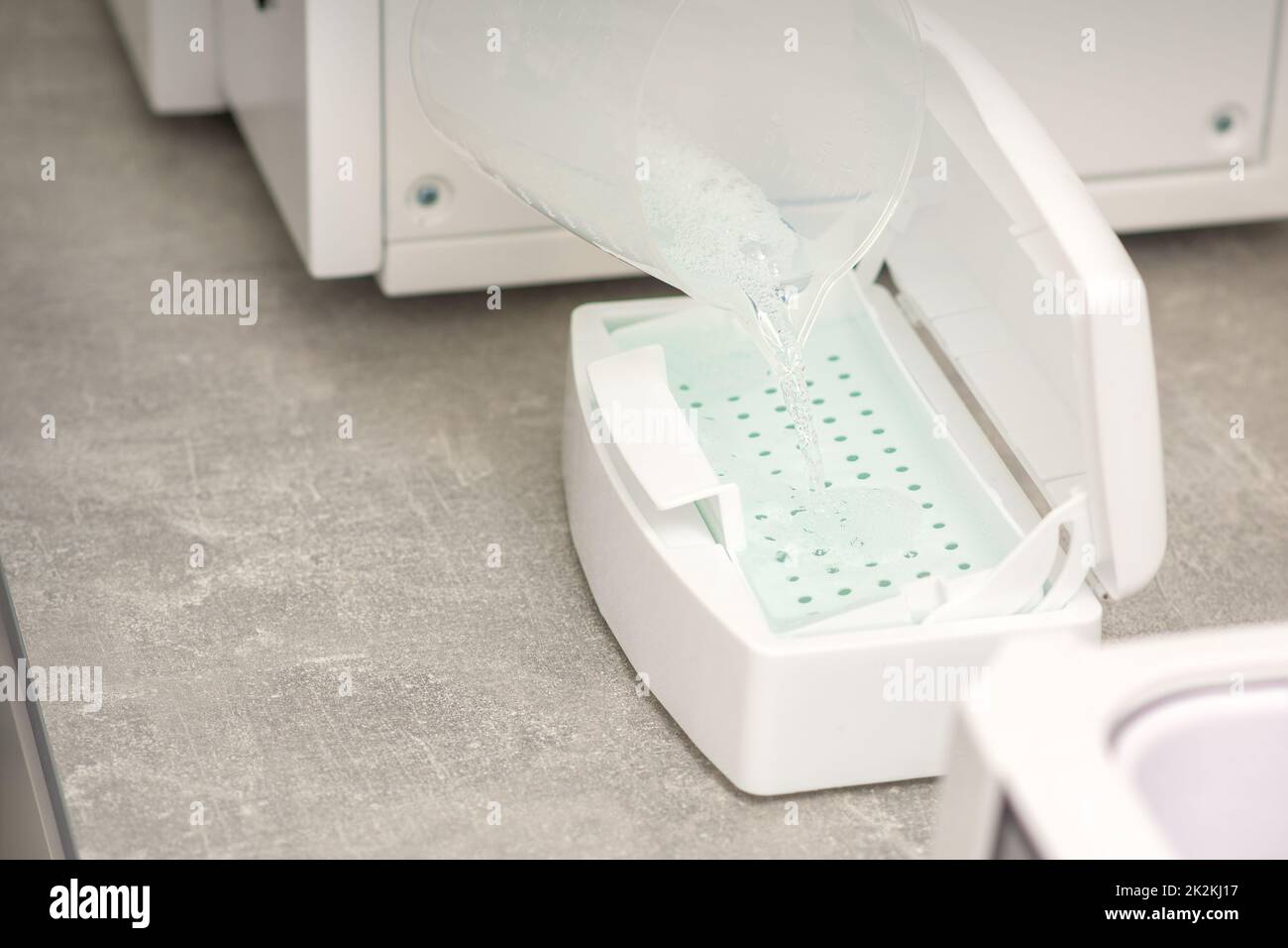 Adding liquid for disinfection of instruments to the machine for ...