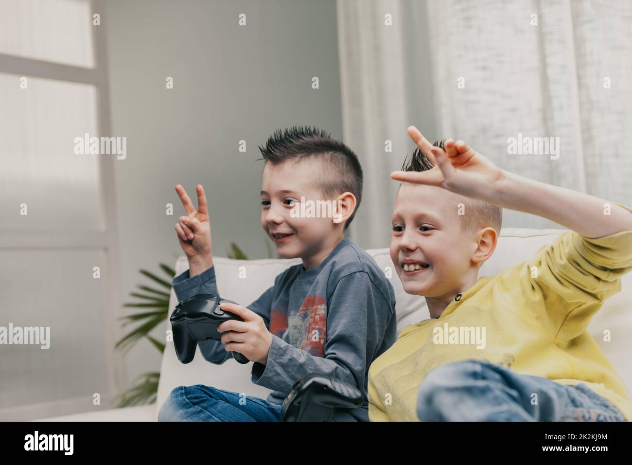 Two successful or triumphant young boys giving V-signs Stock Photo - Alamy
