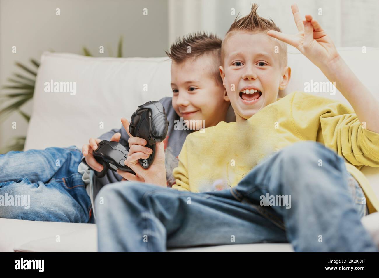 Happy young boy giving Victory sign with his fingers Stock Photo - Alamy