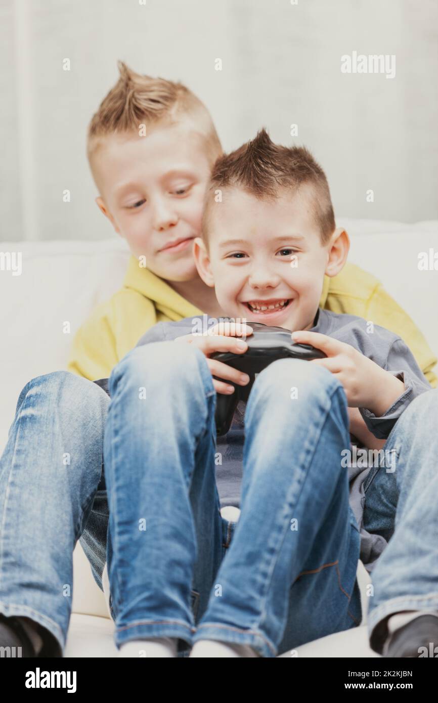 Two mischievous young boys playing video games together Stock Photo - Alamy