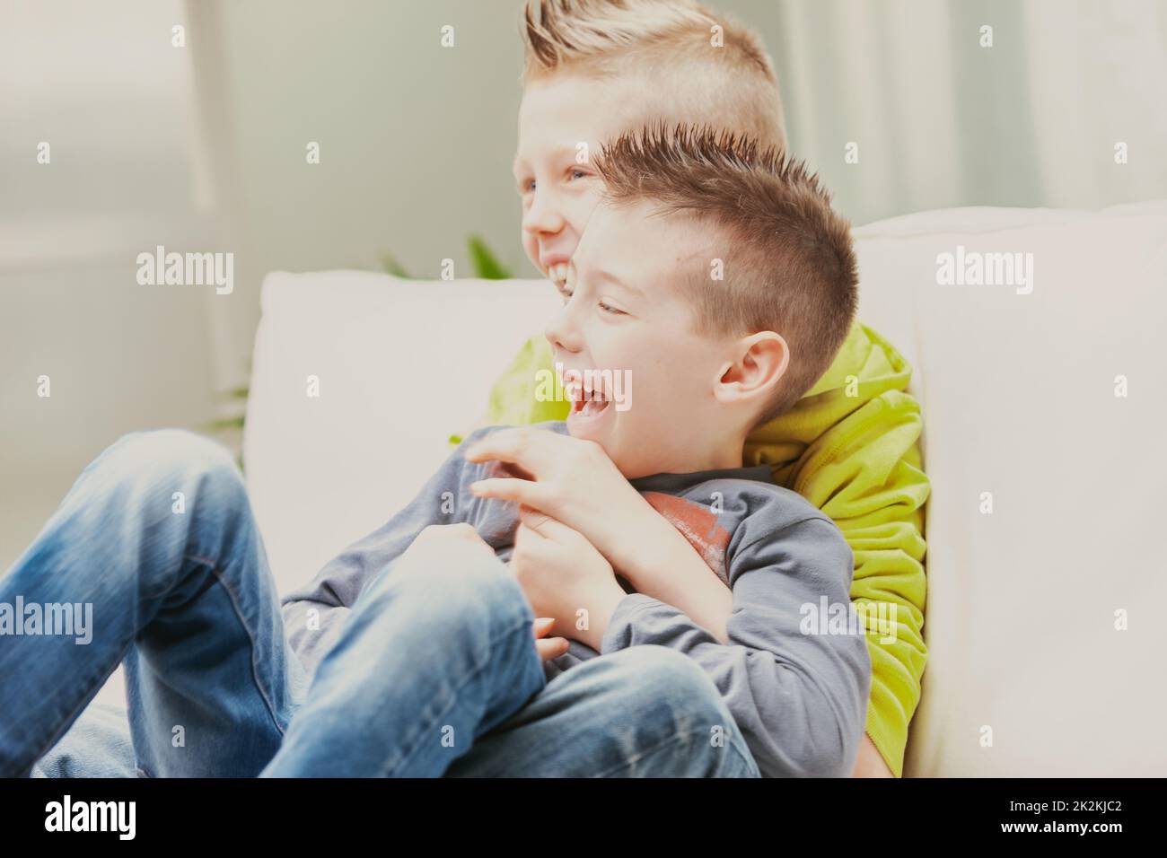Two fun loving young brothers cuddling and laughing Stock Photo - Alamy
