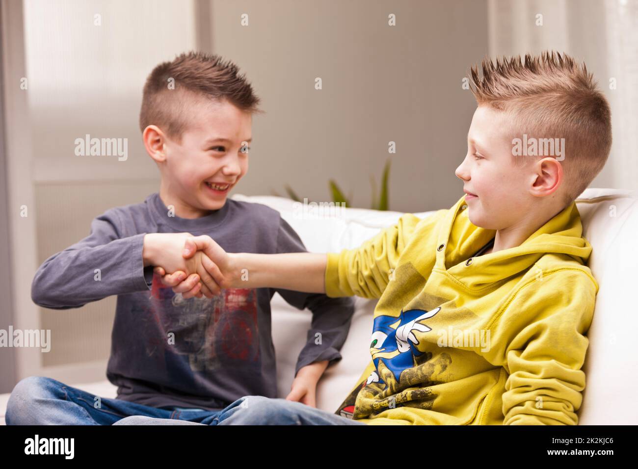 two kids handshaking with a smile Stock Photo - Alamy