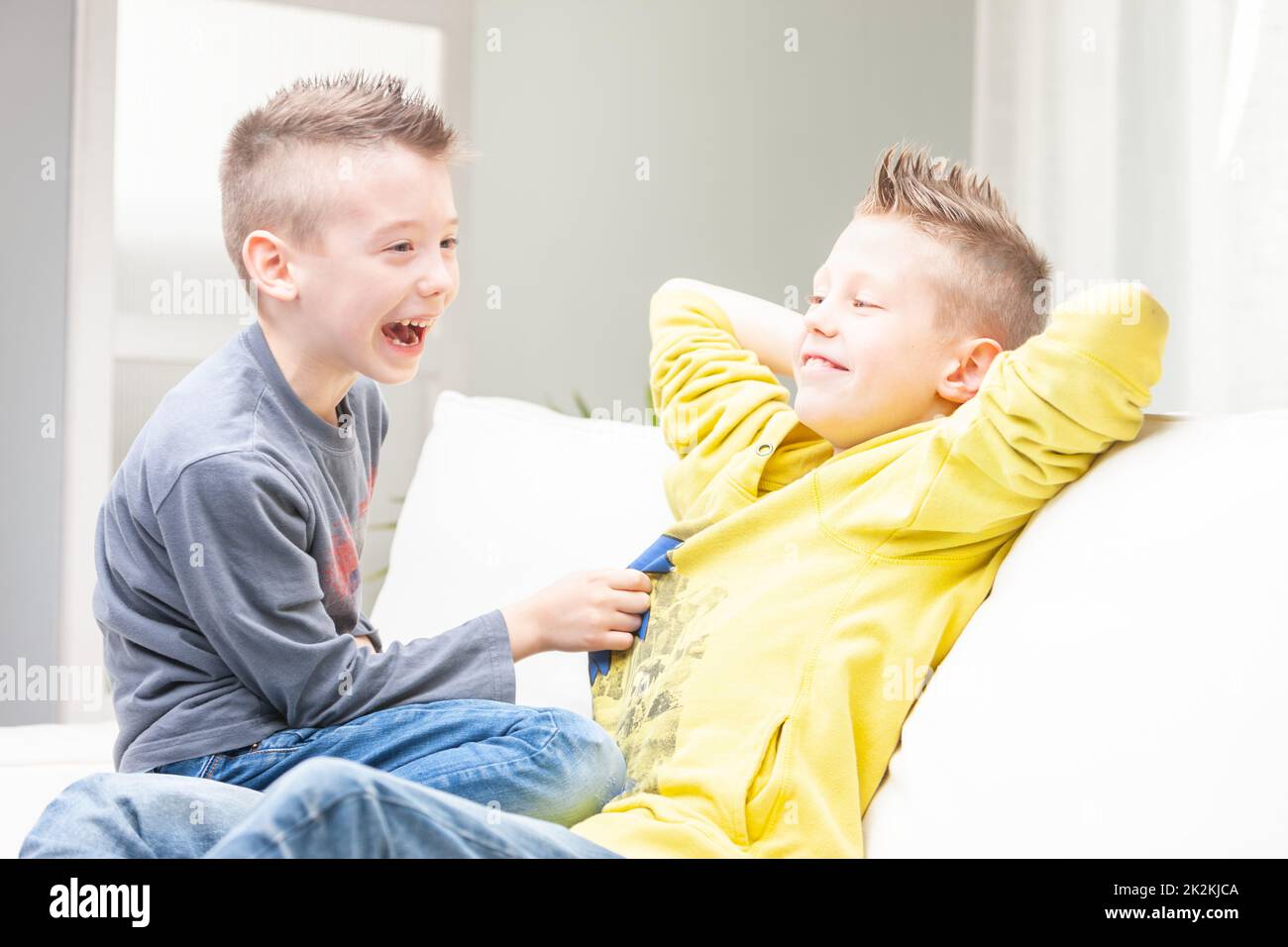 Cute funny young boy laughing at his brother Stock Photo - Alamy